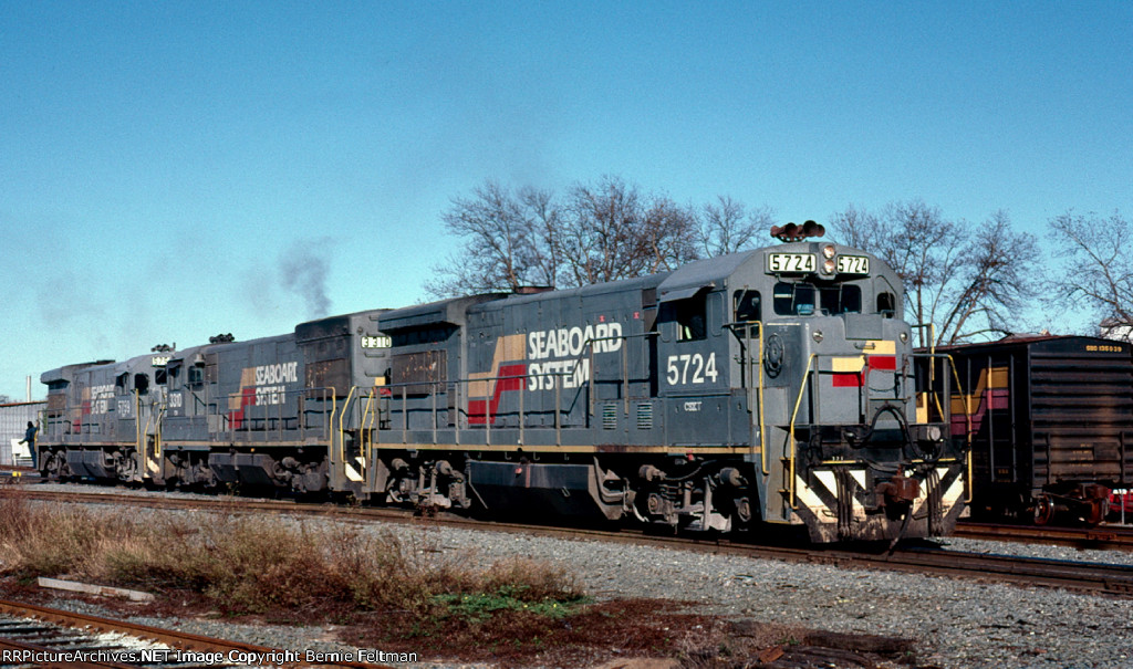 CSX U36B #5724, U23B #3310 and U36B #5759, with the conductor riding the steps of the trailing ...